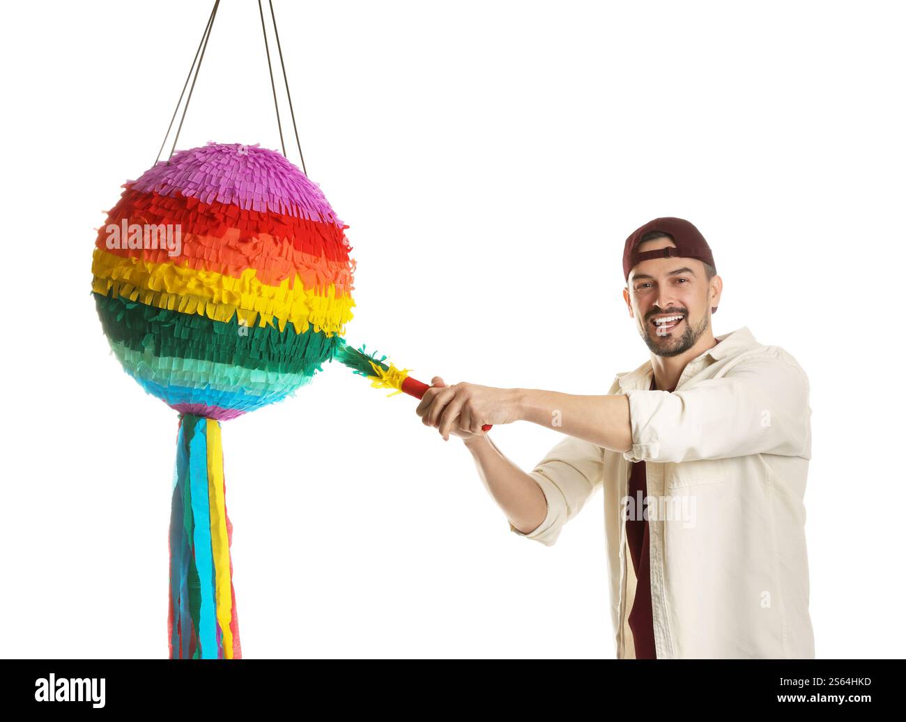 Emotional man hitting colorful pinata with stick on white background ...