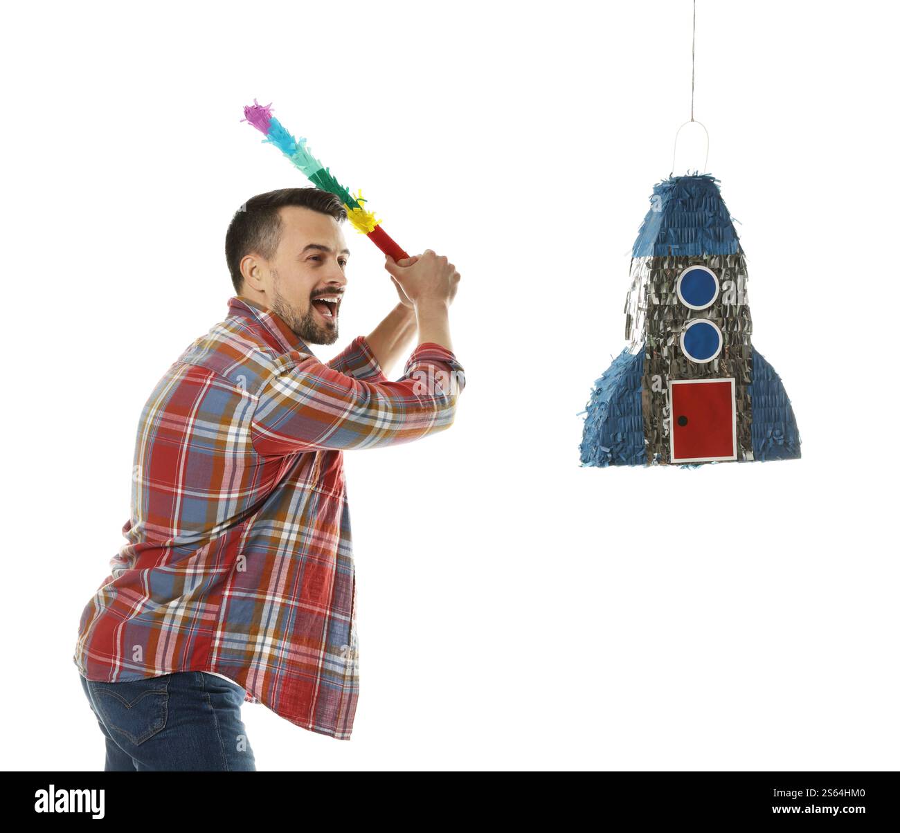 Emotional man hitting rocket shaped pinata with stick on white ...