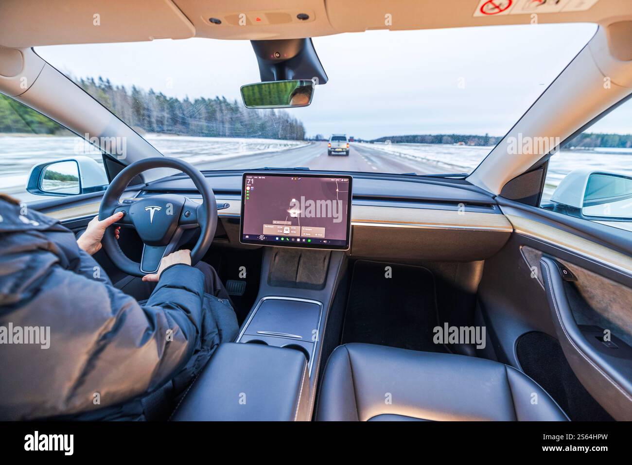 Woman driving Tesla Model Y on winter highway with touchscreen ...