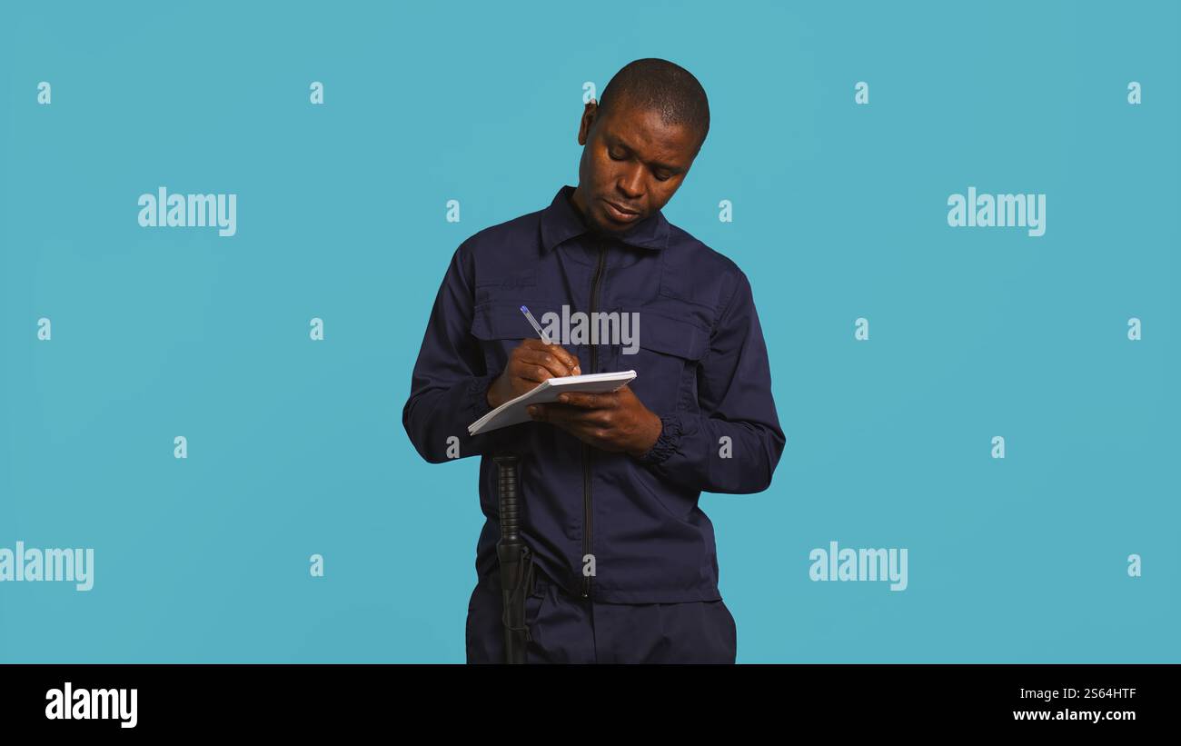 Portrait of security guard using notepad to take notes of suspicious ...