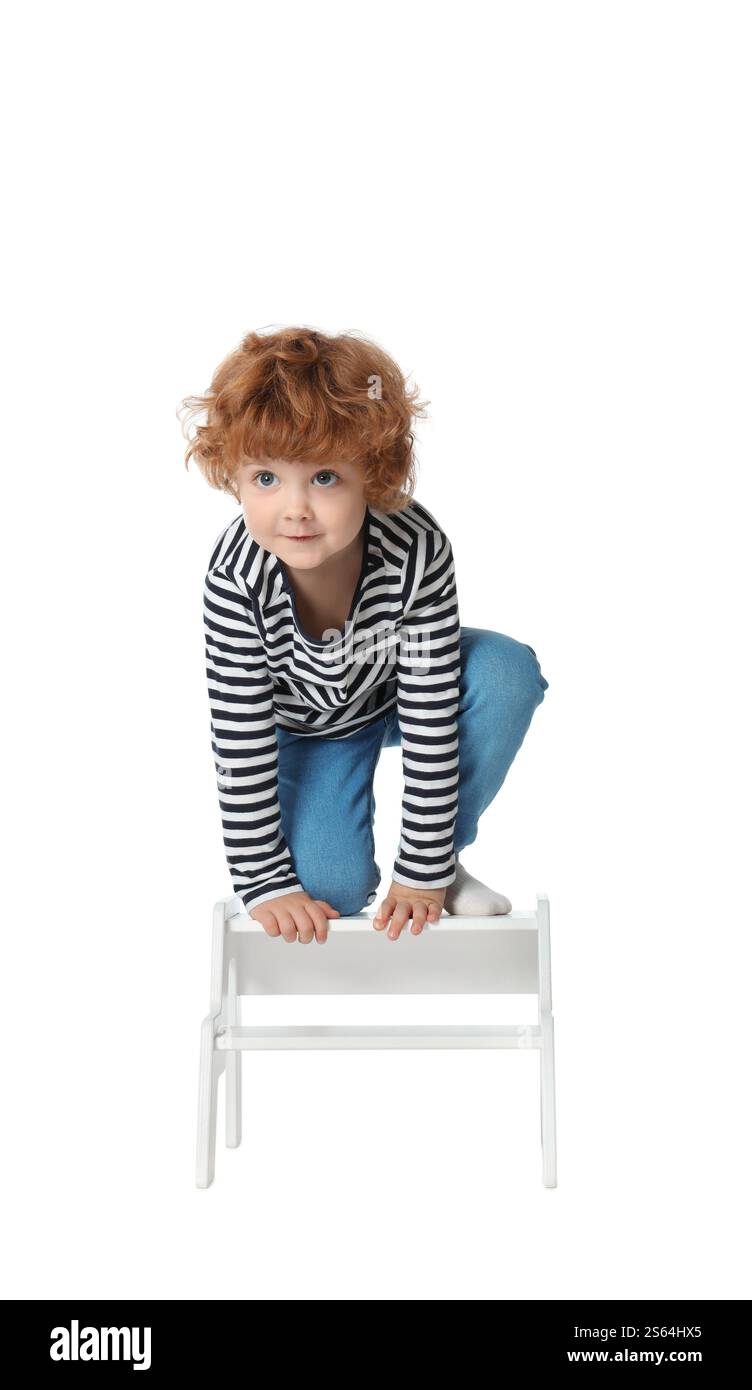 Little boy standing on step stool against white background Stock Photo ...