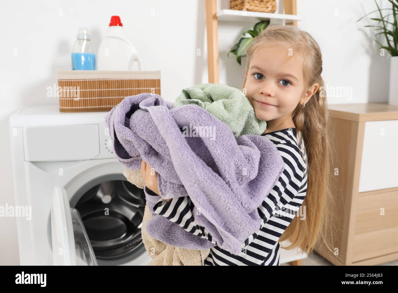 Little helper. Cute girl doing laundry at home Stock Photo - Alamy