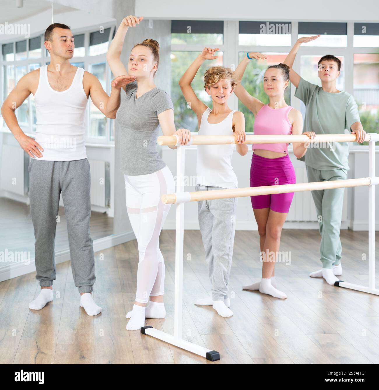 Girls and boys in ballet class perform third position under male ...
