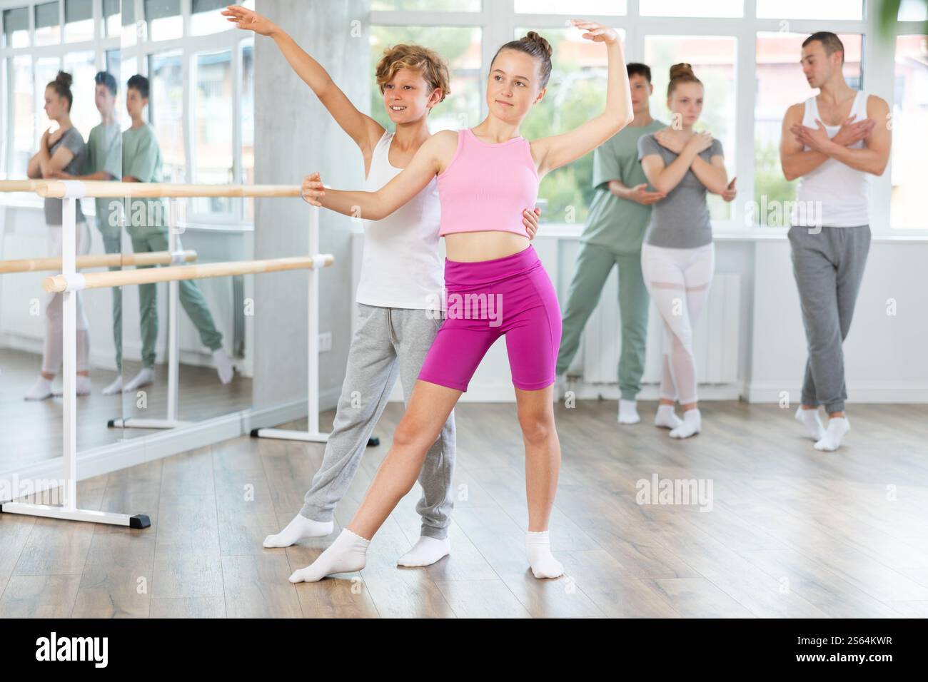 Teenage girl and boy practicing ballet positions in pair in dance ...