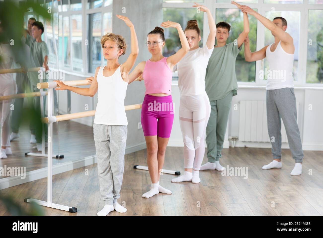 Girls and boys in ballet class perform third position under male ...