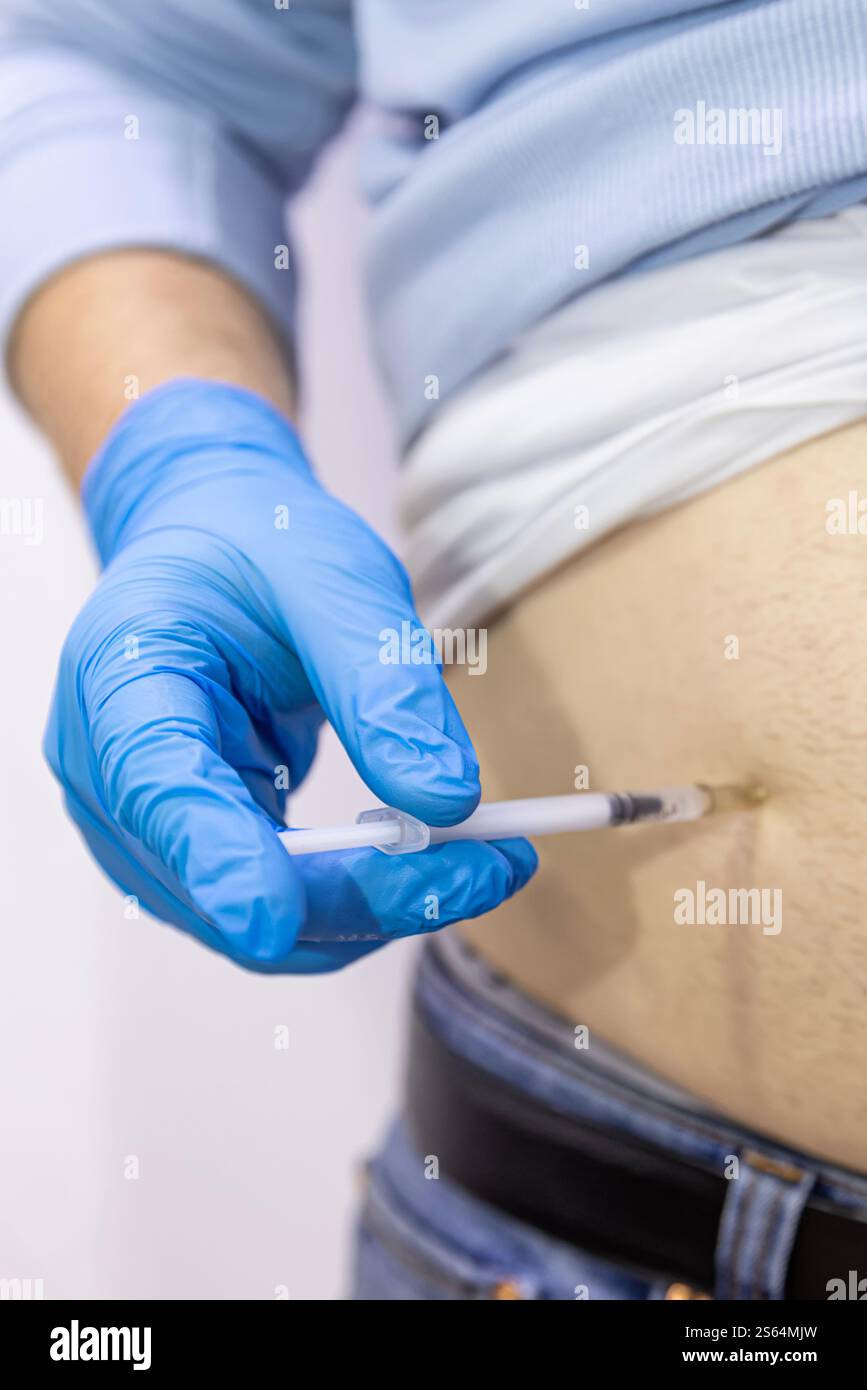 How to properly give yourself subcutaneous injection in your stomach concept. Cropped photo of a ...