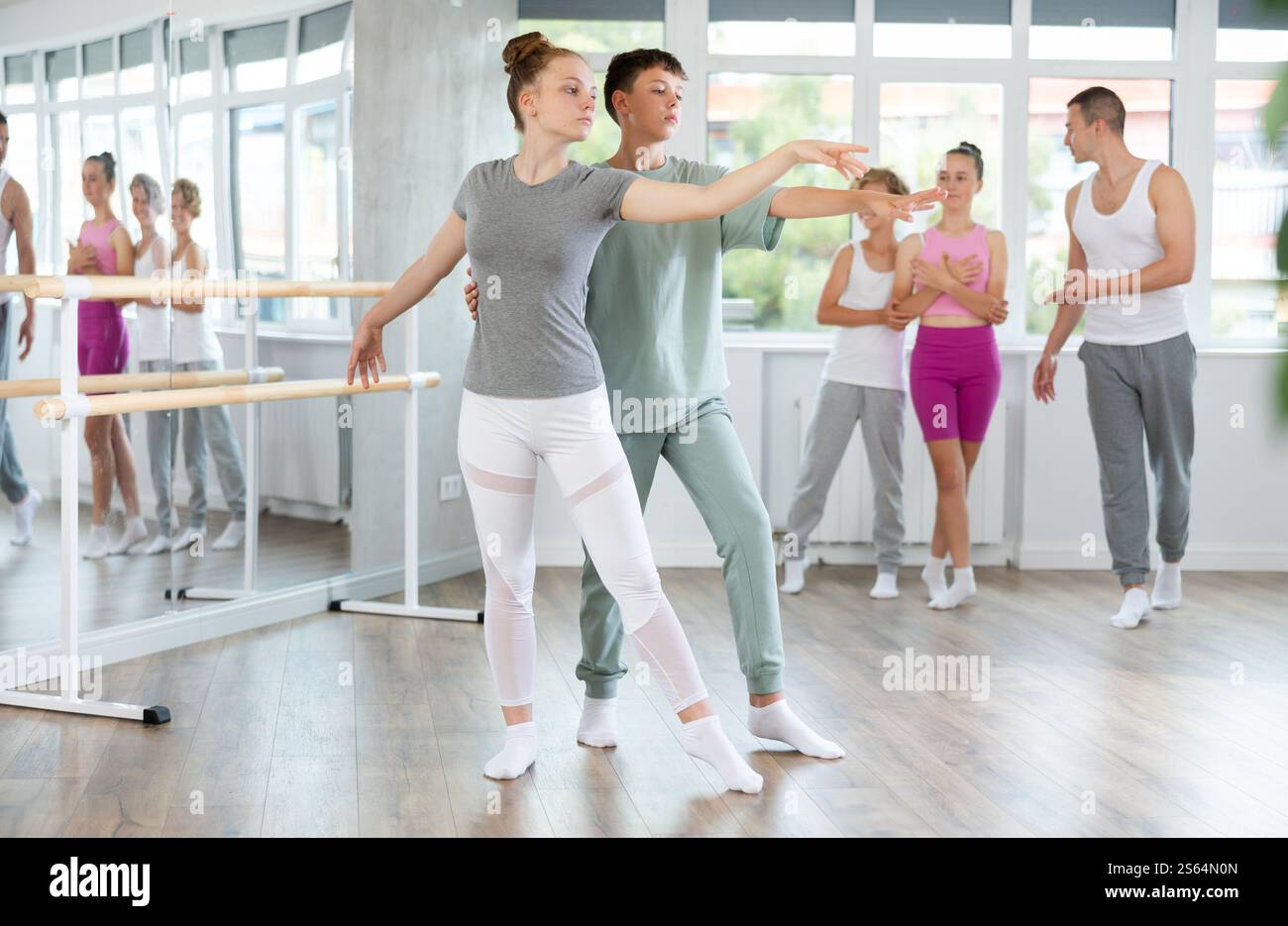 Ballet studio - teenagers girls and boys learn ballet movements in ...