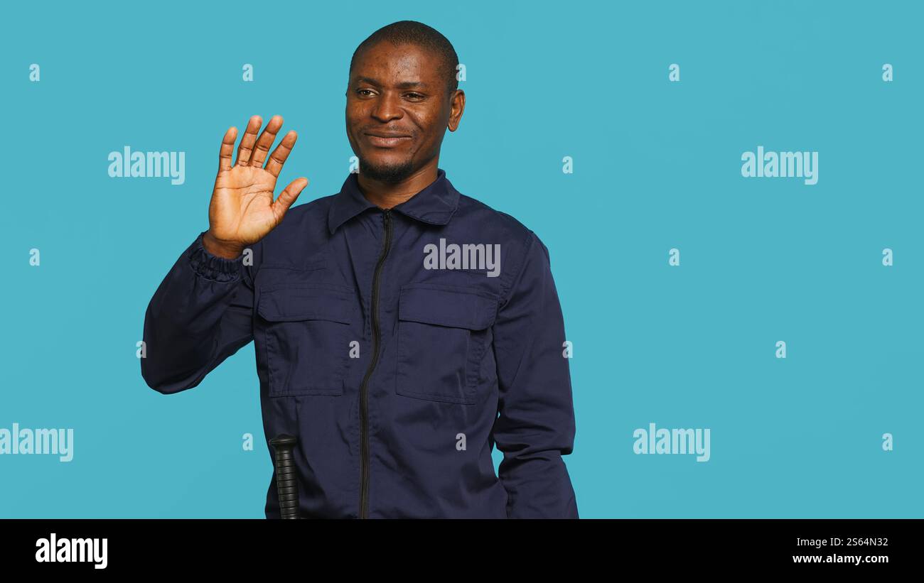 Smiling security guard saluting people during surveillance shift ...