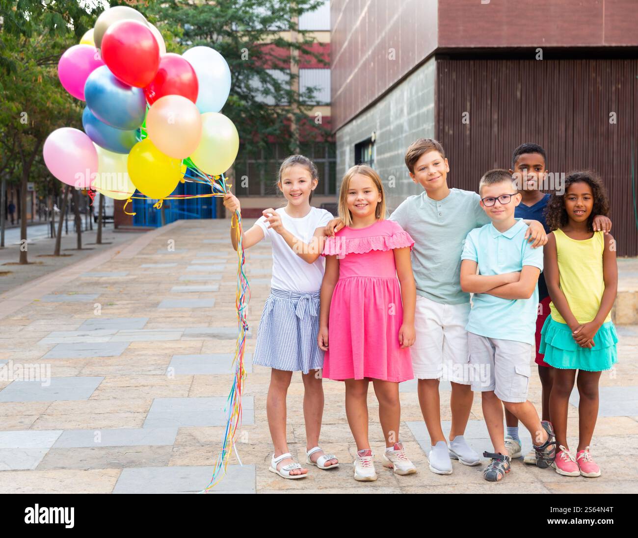Full length portrait of happy tweens with balloons on city street Stock ...