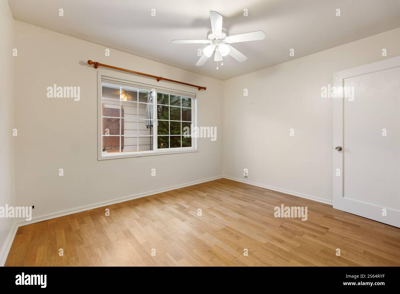 Light-filled living area features elegant wooden flooring and high ...