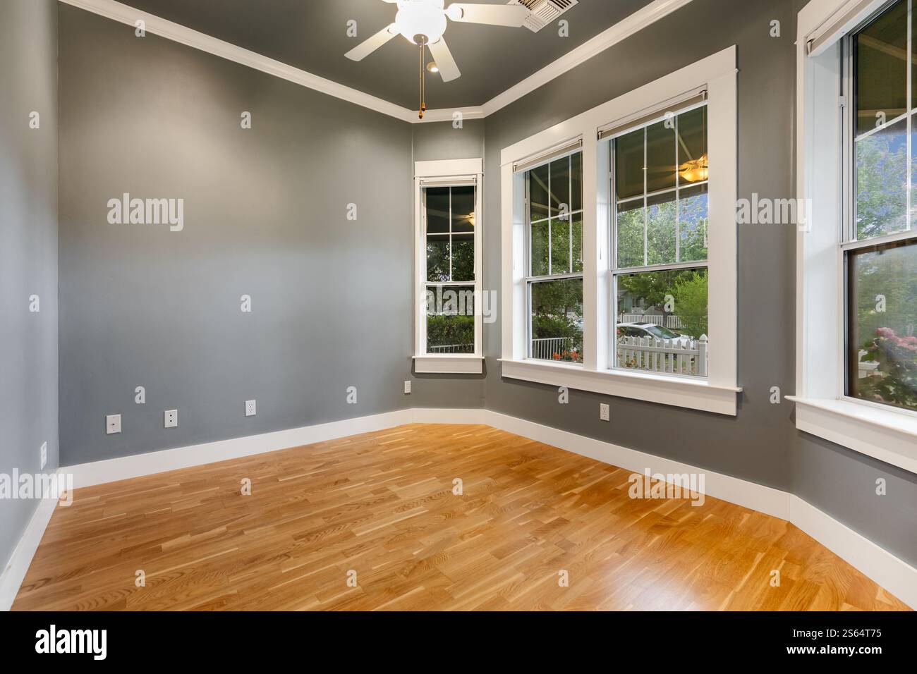 Light-filled living area features elegant wooden flooring and high ...