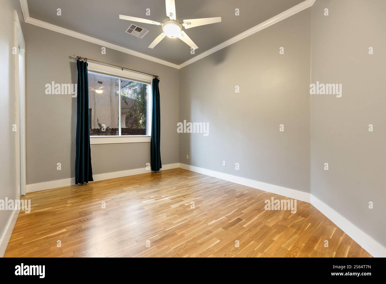 Light-filled living area features elegant wooden flooring and high ...