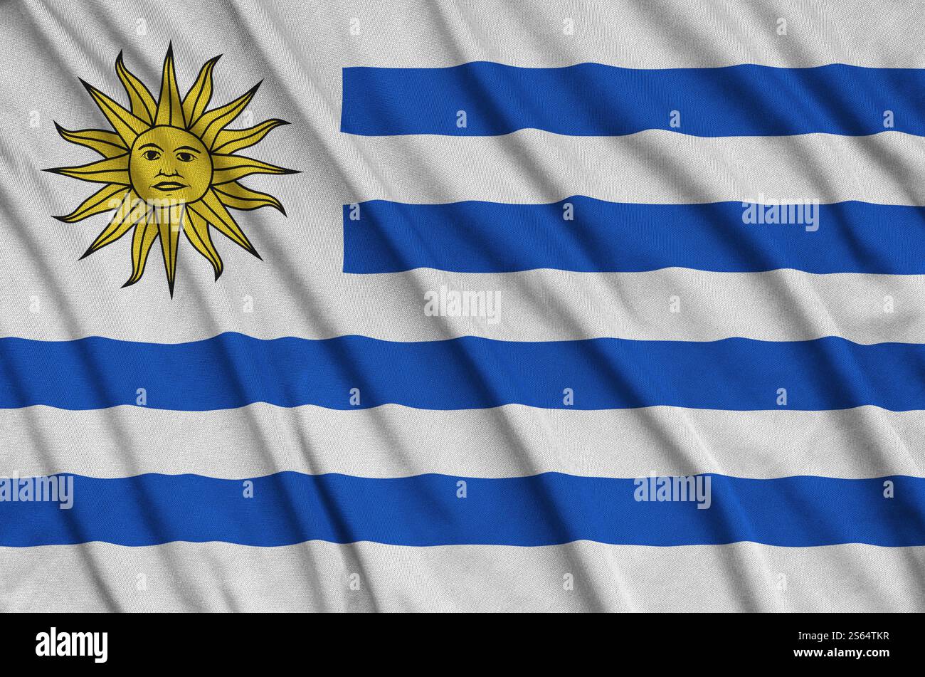 Uruguay flag is depicted on a sports cloth fabric with many folds ...