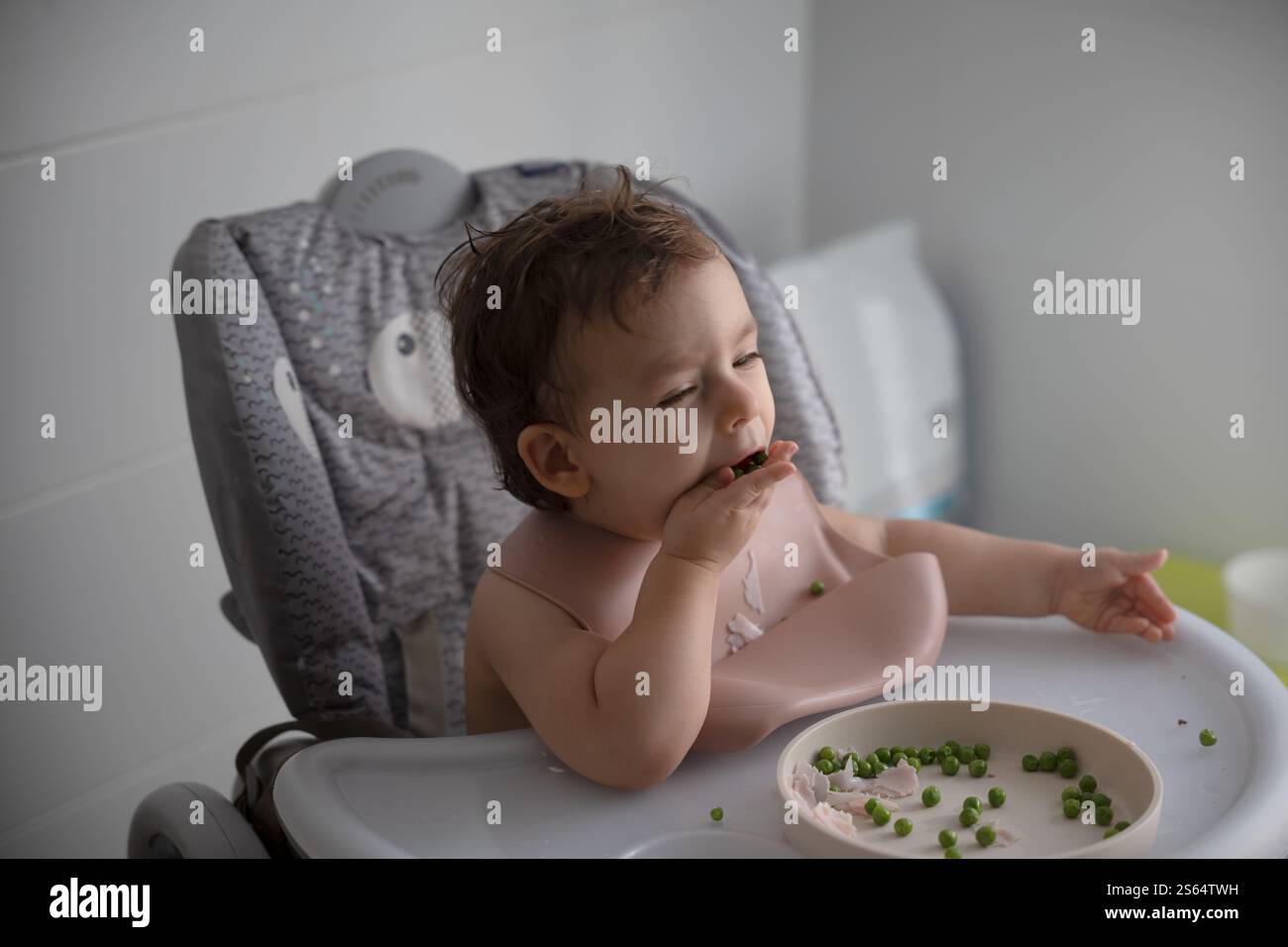 Baby learns to eat peas with baby led weaning method Stock Photo - Alamy