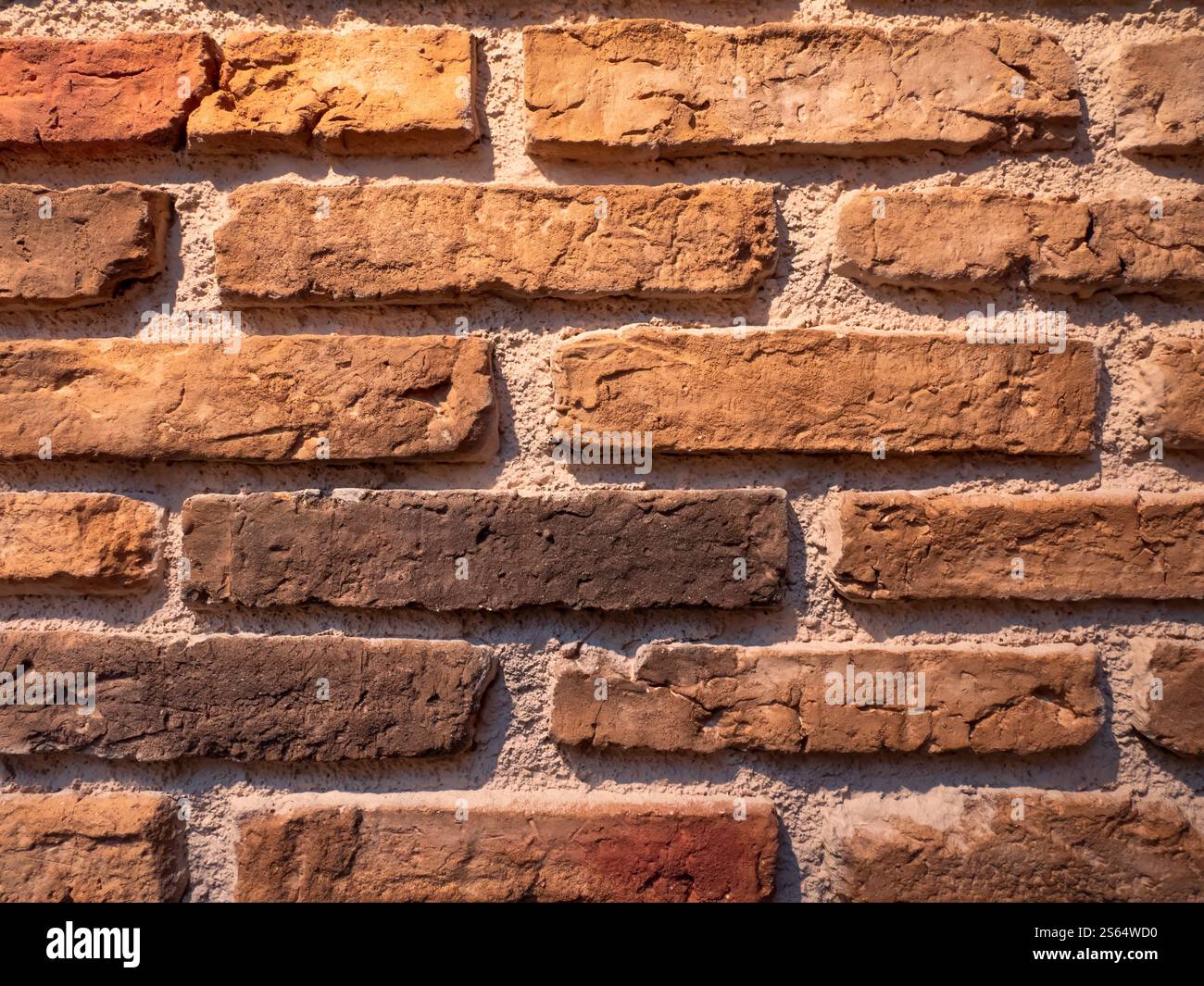 Close-up texture of a rustic brick wall with varied colors, suitable ...