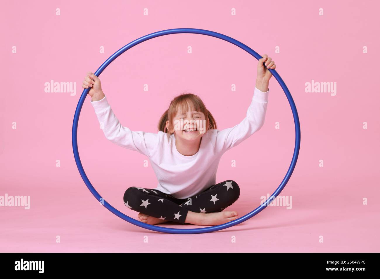 Cute little girl with hula hoop on pink background Stock Photo - Alamy