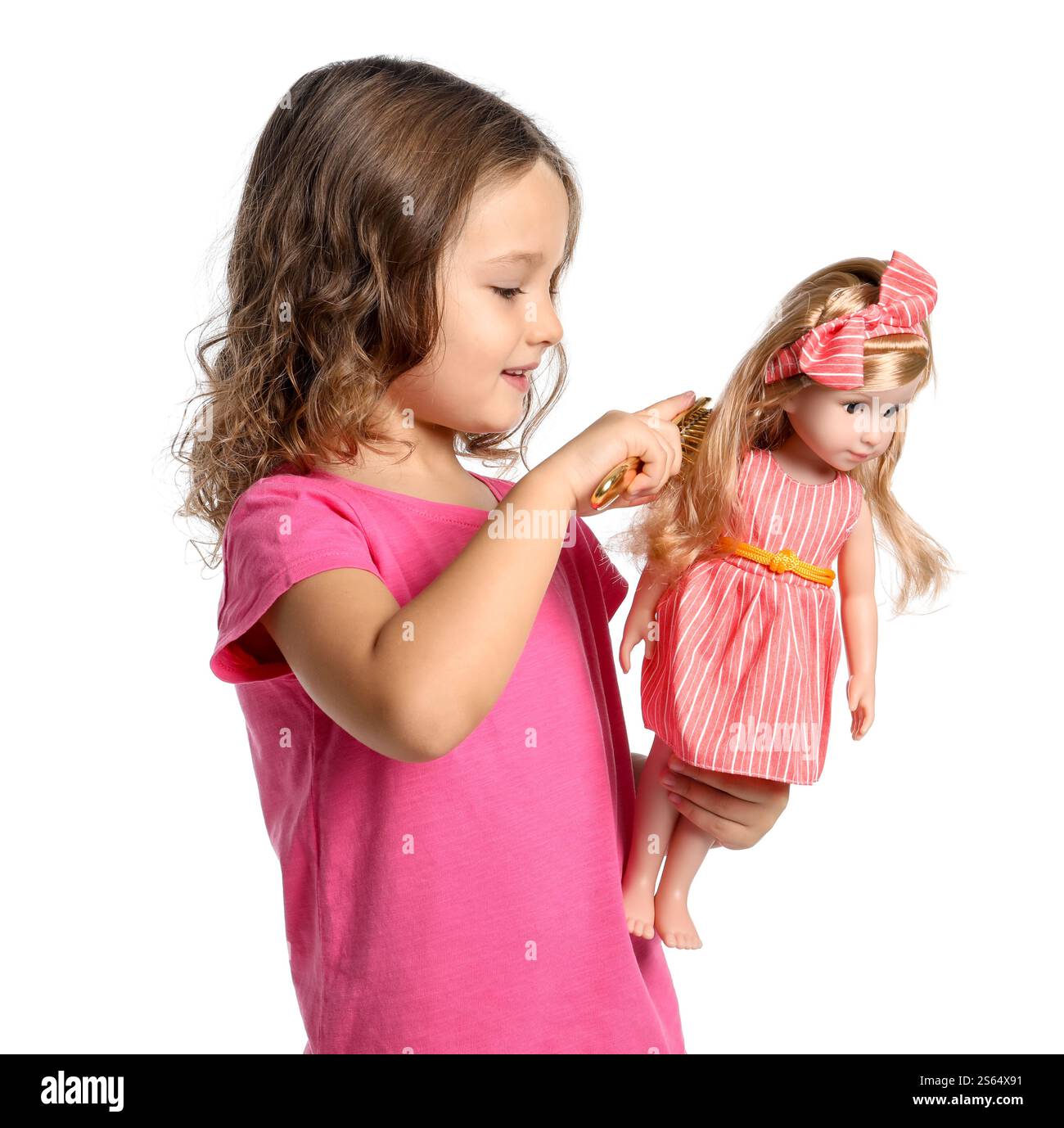 Cute little girl brushing doll's hair on white background Stock Photo ...