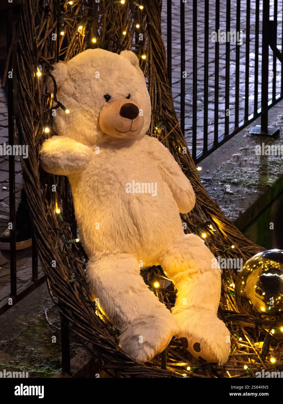 A cuddly giant teddy bear enjoys the festive atmosphere, nestled ...