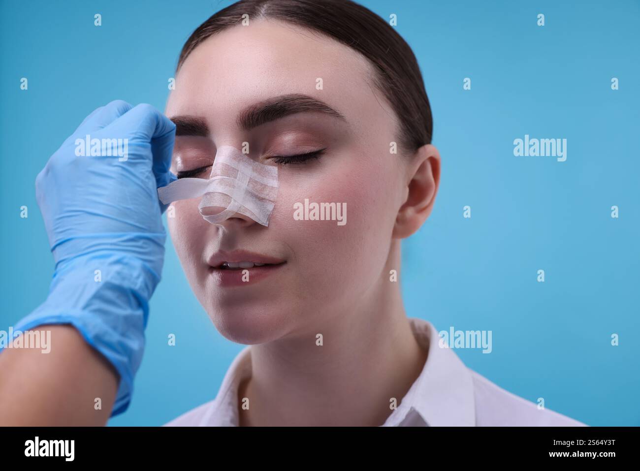 Doctor removing medical bandage from patient's nose after plastic ...