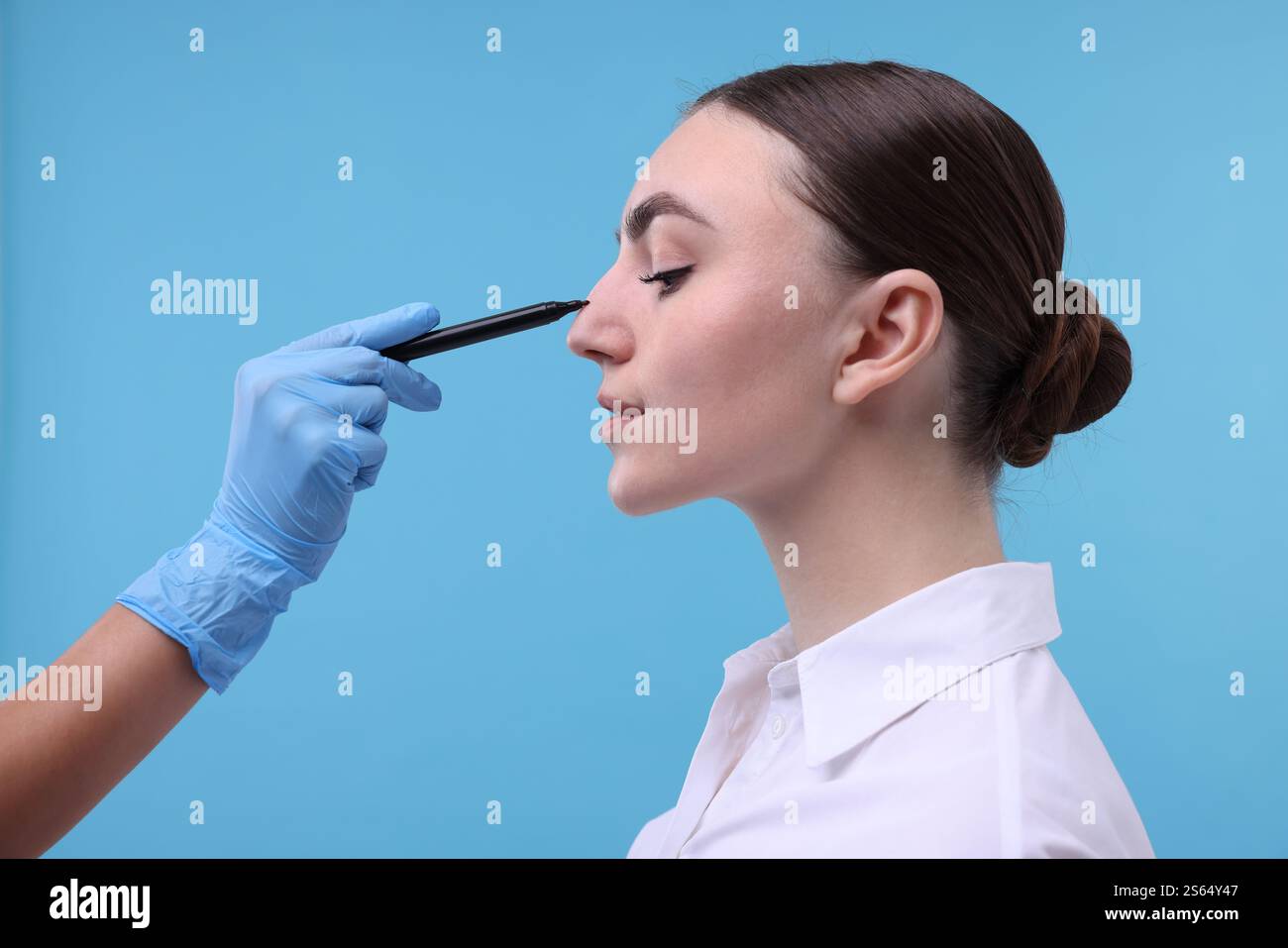 Doctor drawing marks on patient's nose for plastic surgery operation ...