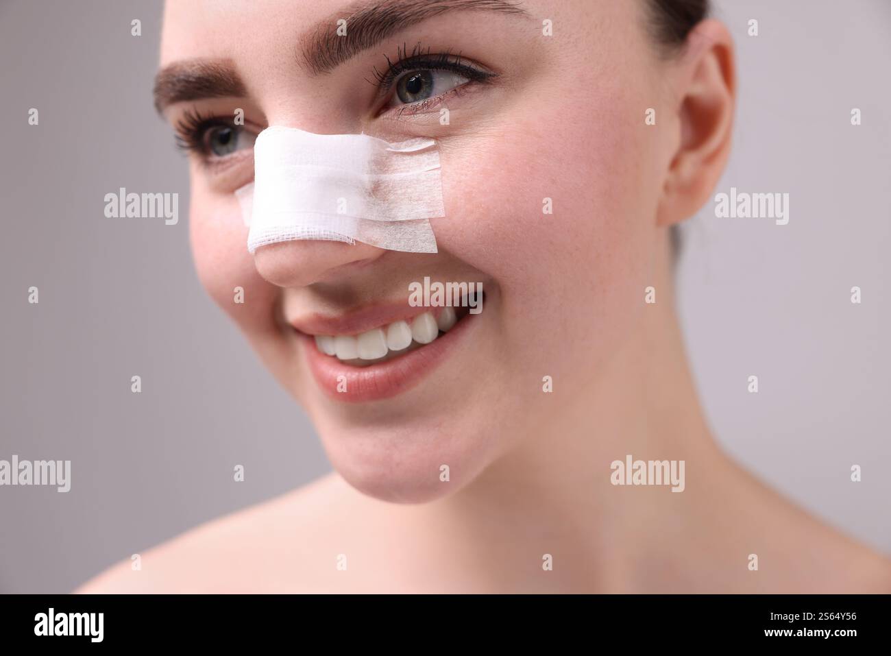 Woman with medical bandage on her nose after plastic surgery operation ...