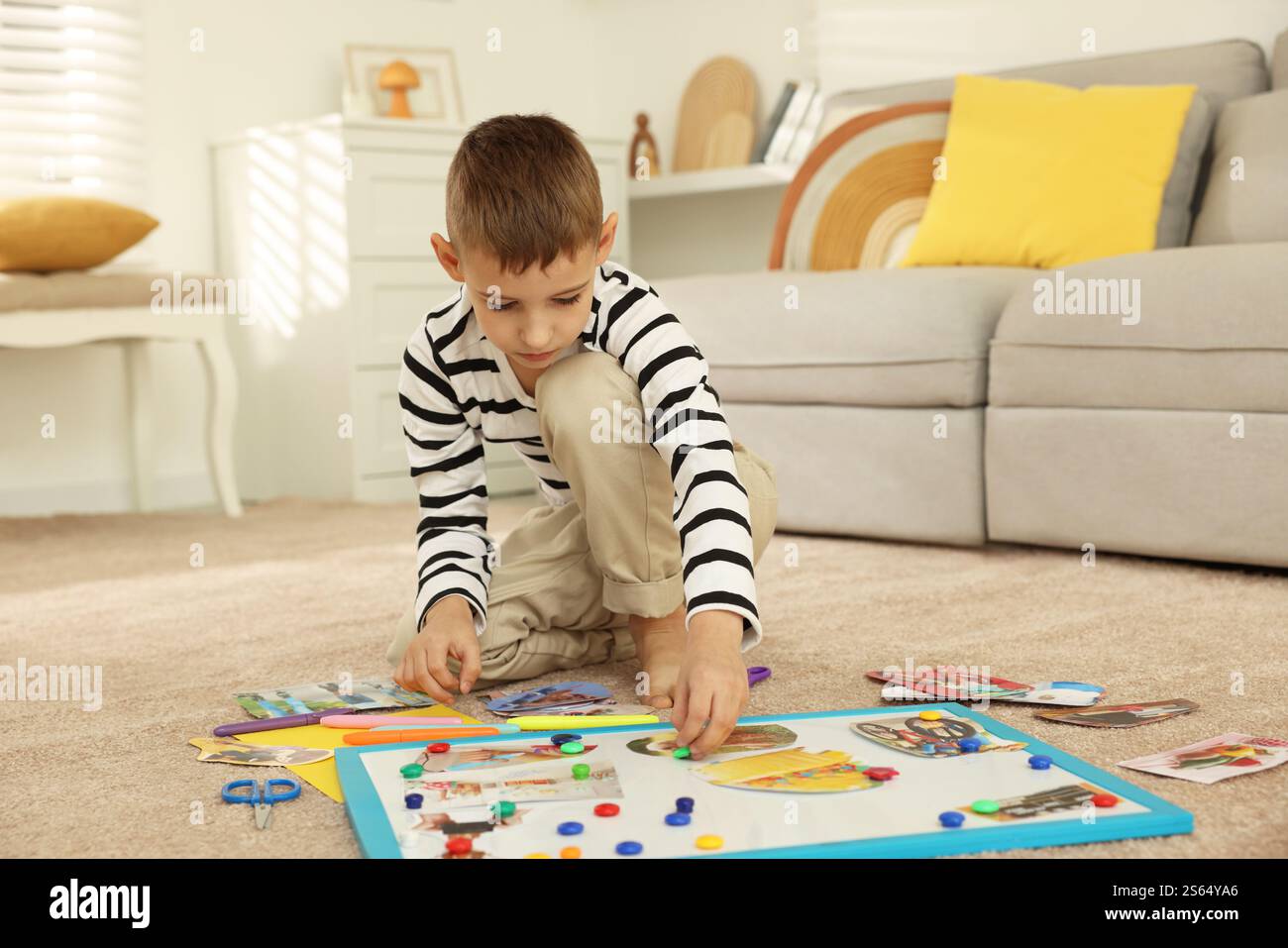 Little boy creating vision board with different pictures and other ...
