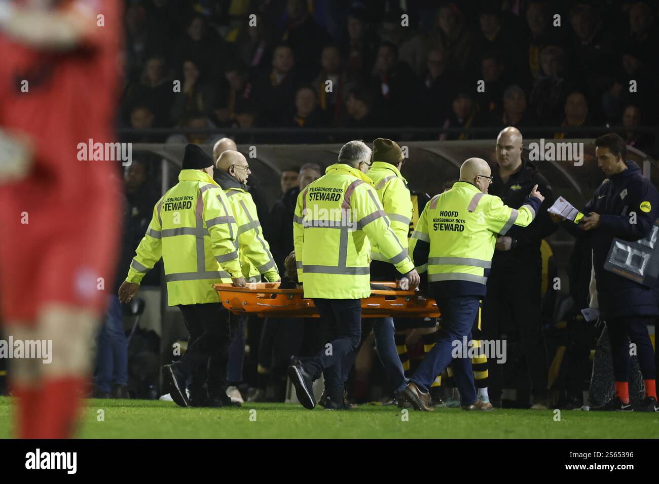RIJNSBURG - A supporter is carried off the field by stretcher during ...