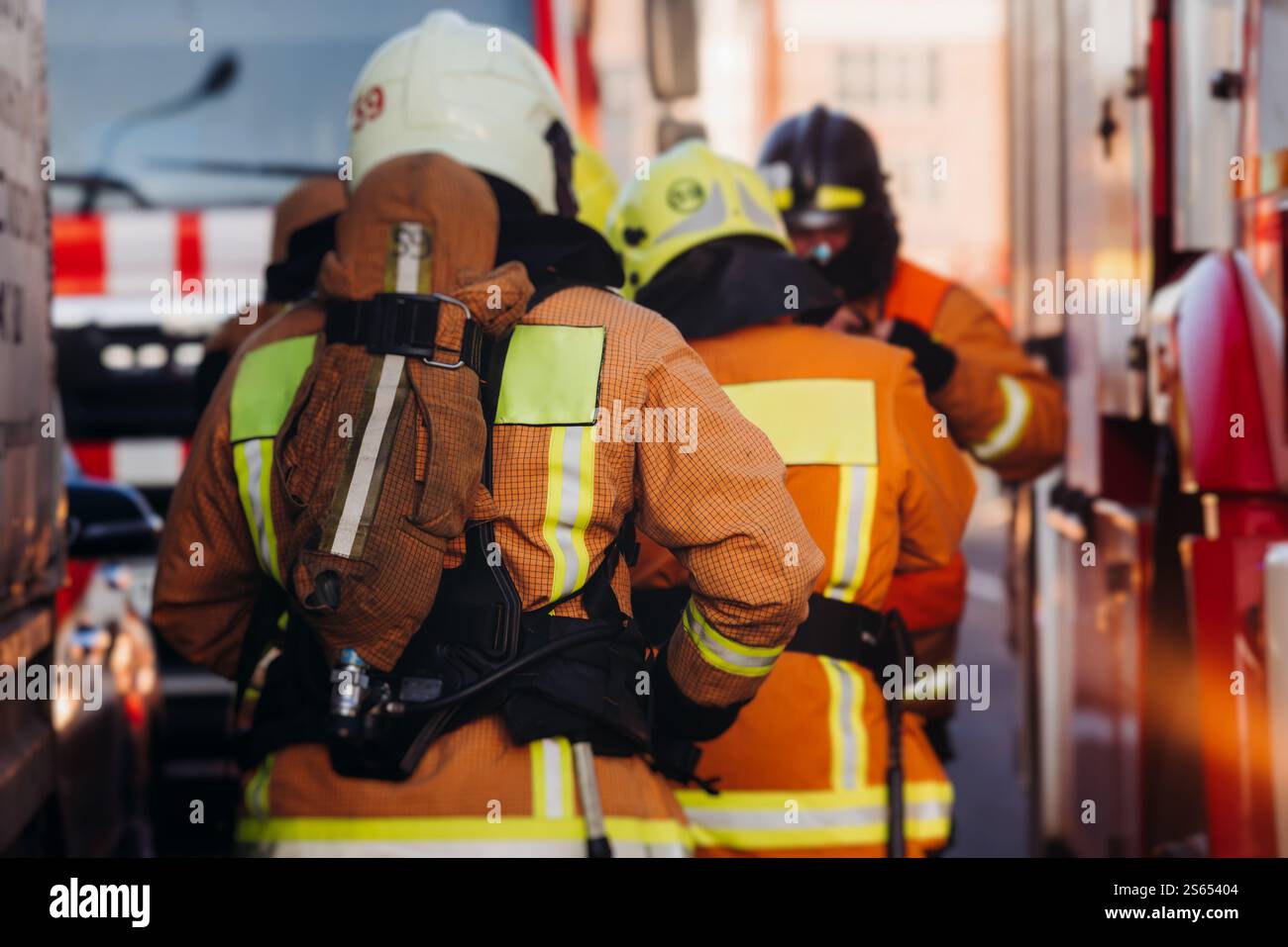 Group of fire men in uniform during fire fighting operation in the city ...