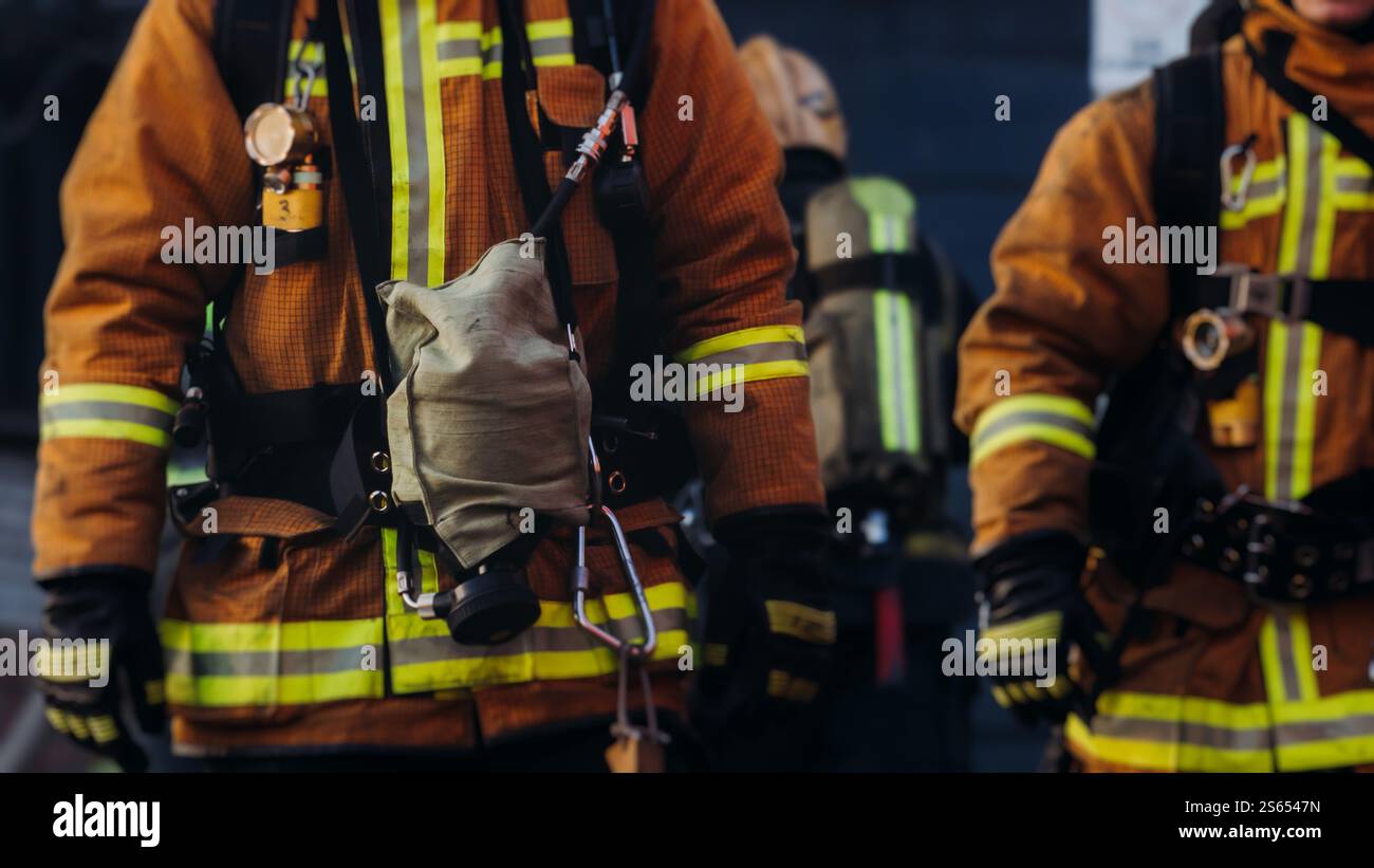 Group of fire men in uniform during fire fighting operation in the city ...
