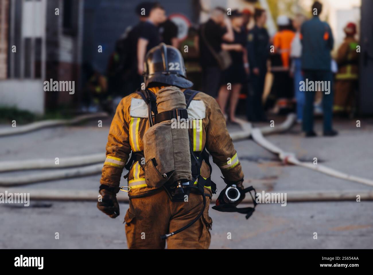 Group of fire men in uniform during fire fighting operation in the city ...
