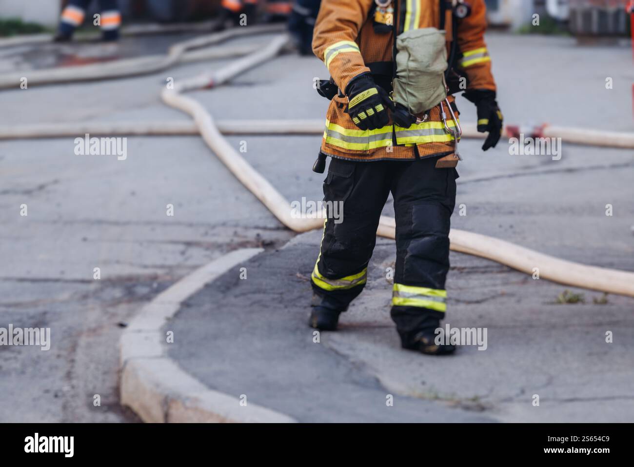 Group of fire men in uniform during fire fighting operation in the city ...