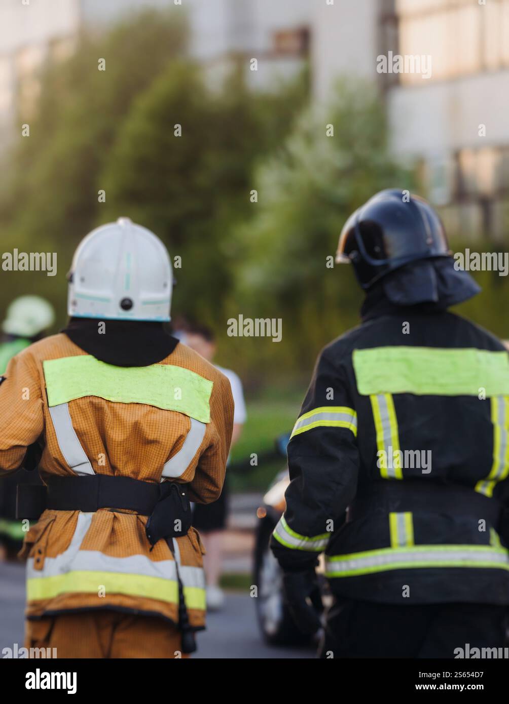 Group of fire men in uniform during fire fighting operation in the city ...