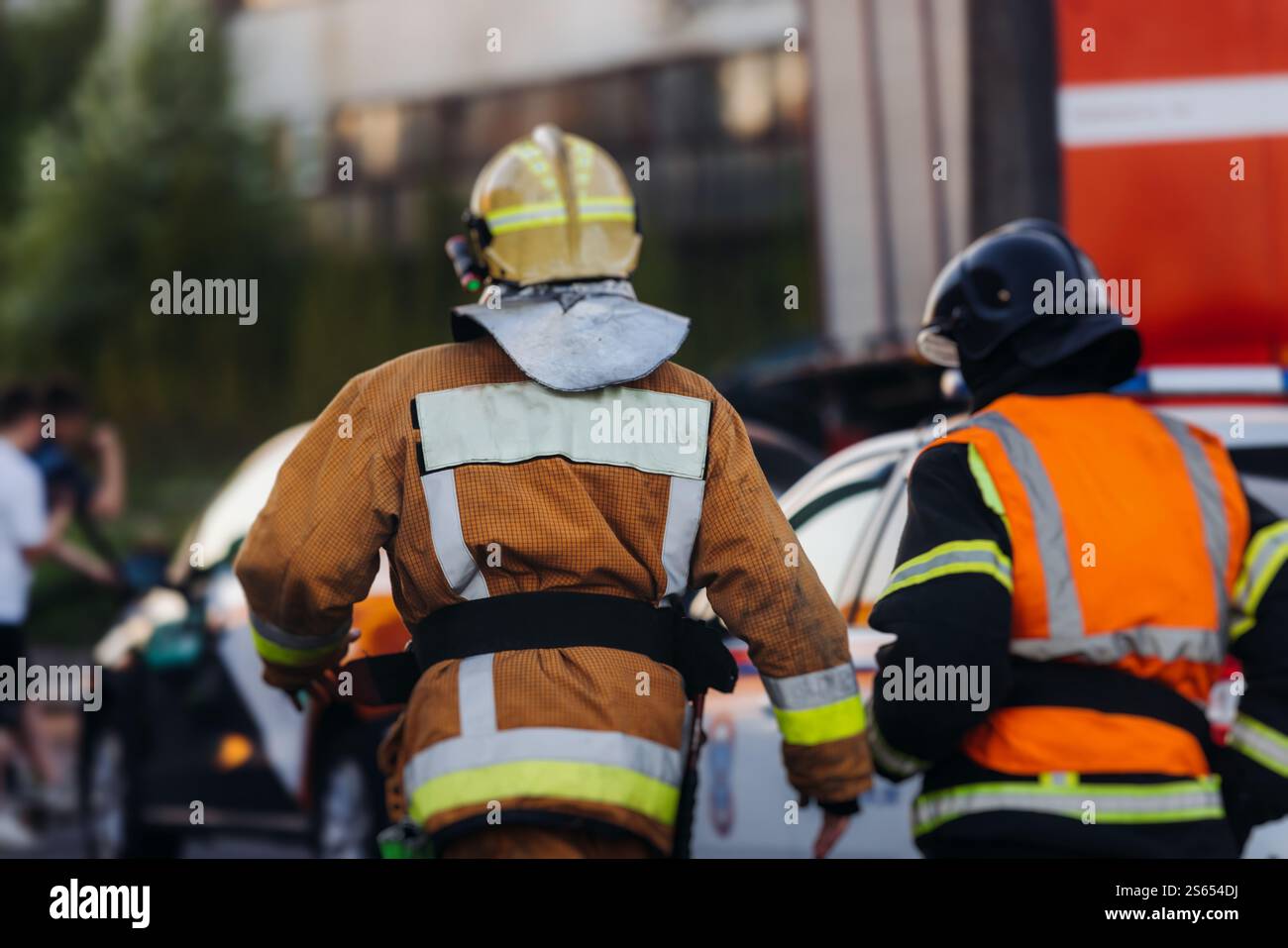 Group of fire men in uniform during fire fighting operation in the city ...