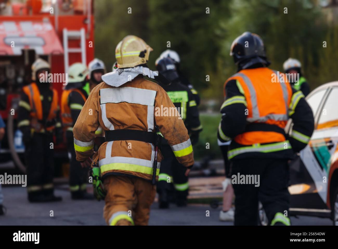 Group of fire men in uniform during fire fighting operation in the city ...