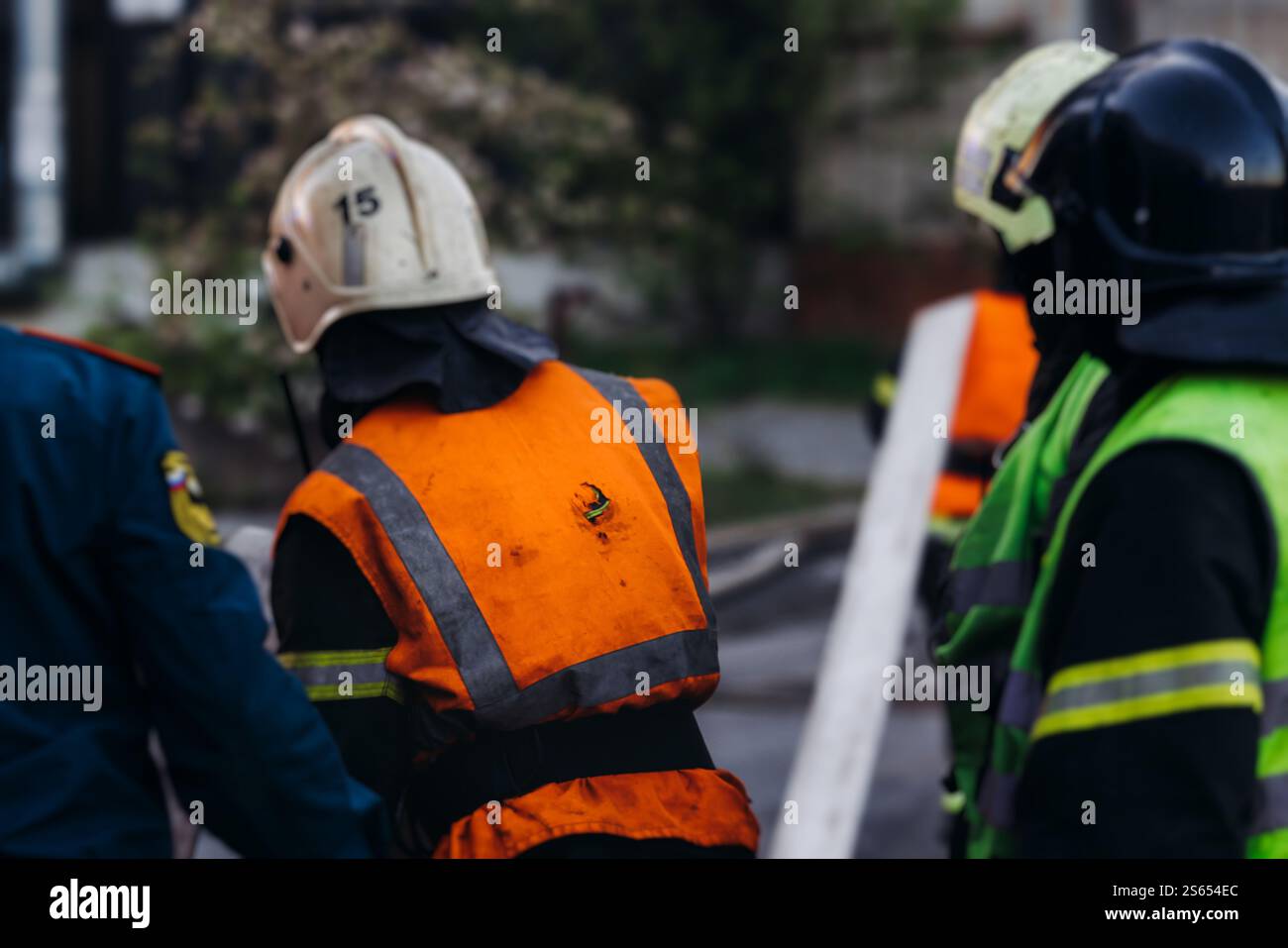 Group of fire men in uniform during fire fighting operation in the city ...