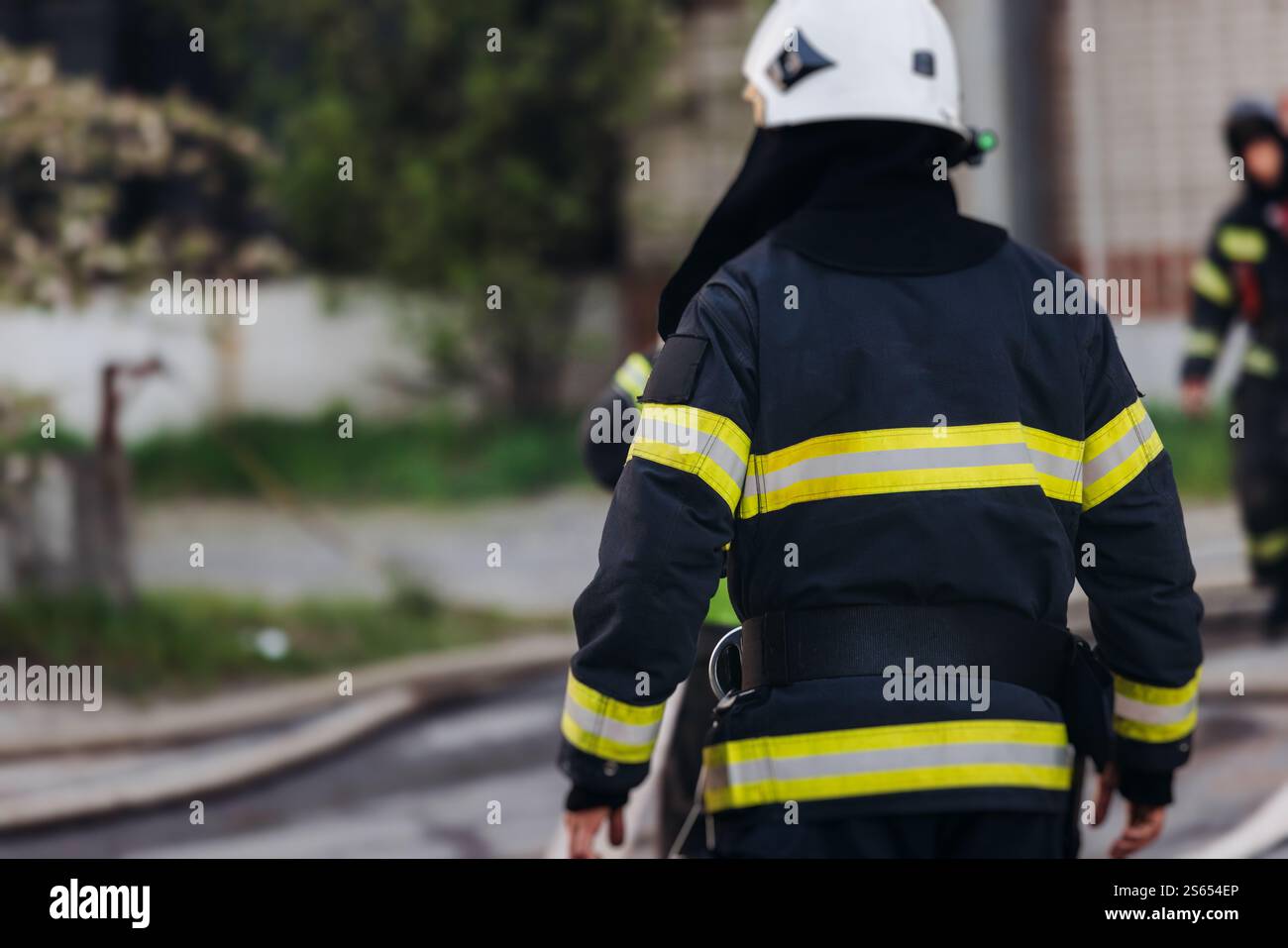 Group of fire men in uniform during fire fighting operation in the city ...
