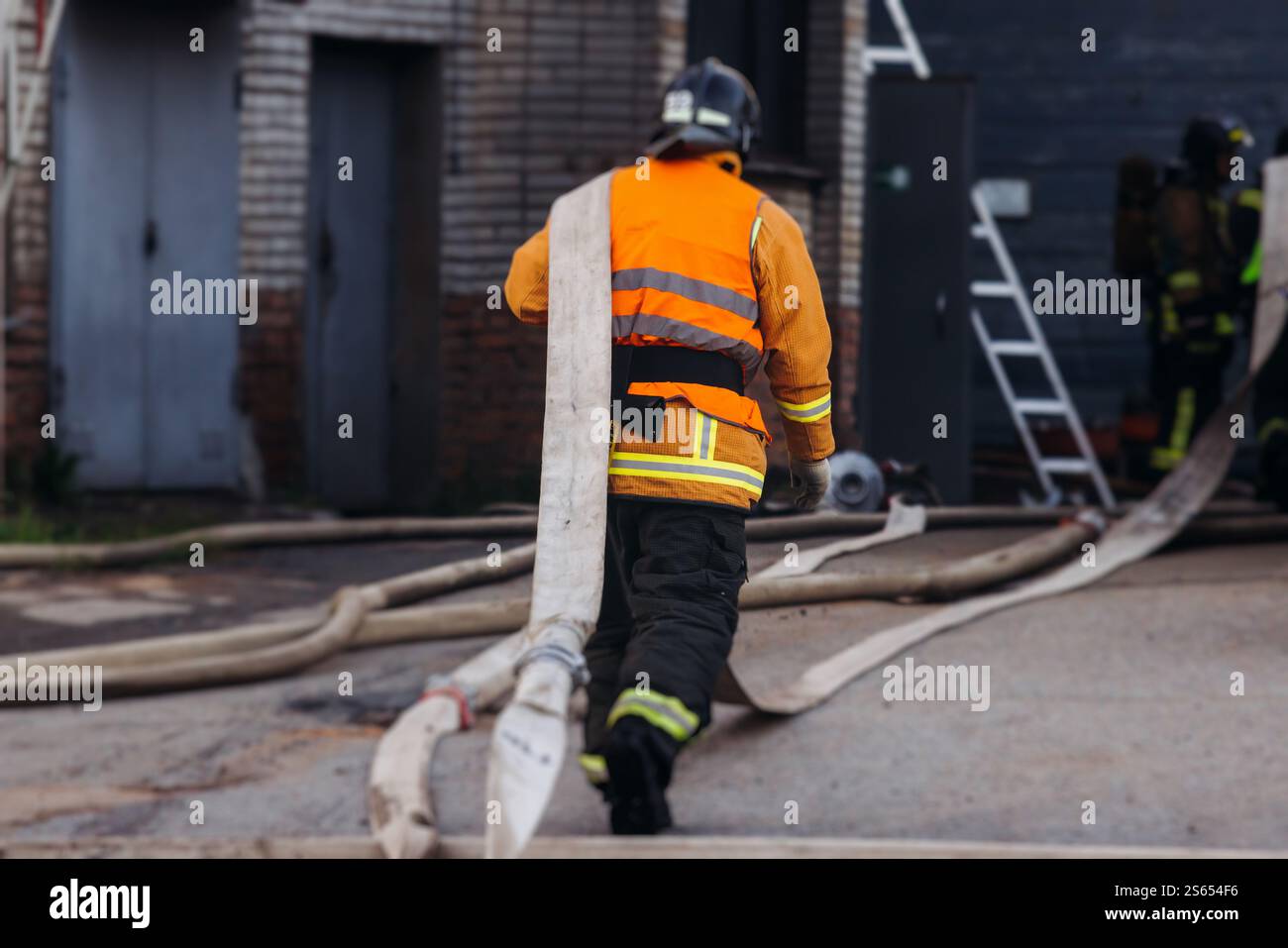 Group of fire men in uniform during fire fighting operation in the city ...