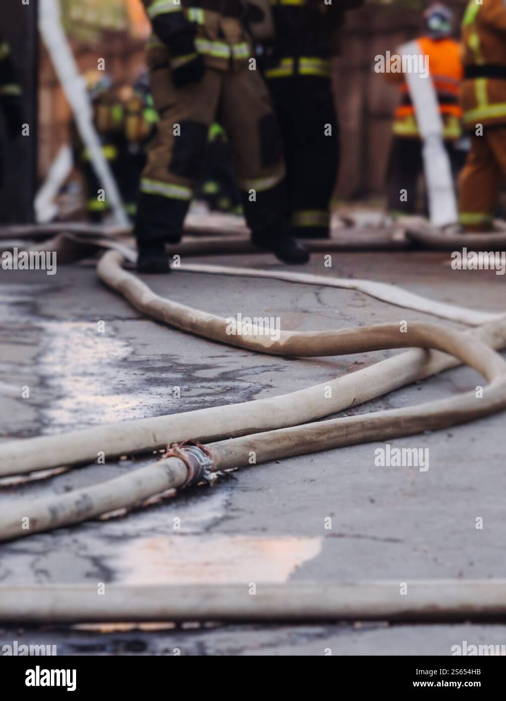 Group of fire men in uniform during fire fighting operation in the city ...