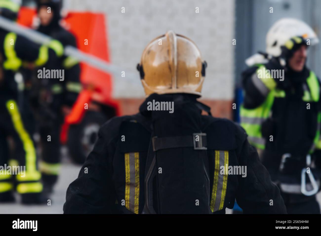 Group of fire men in uniform during fire fighting operation in the city ...