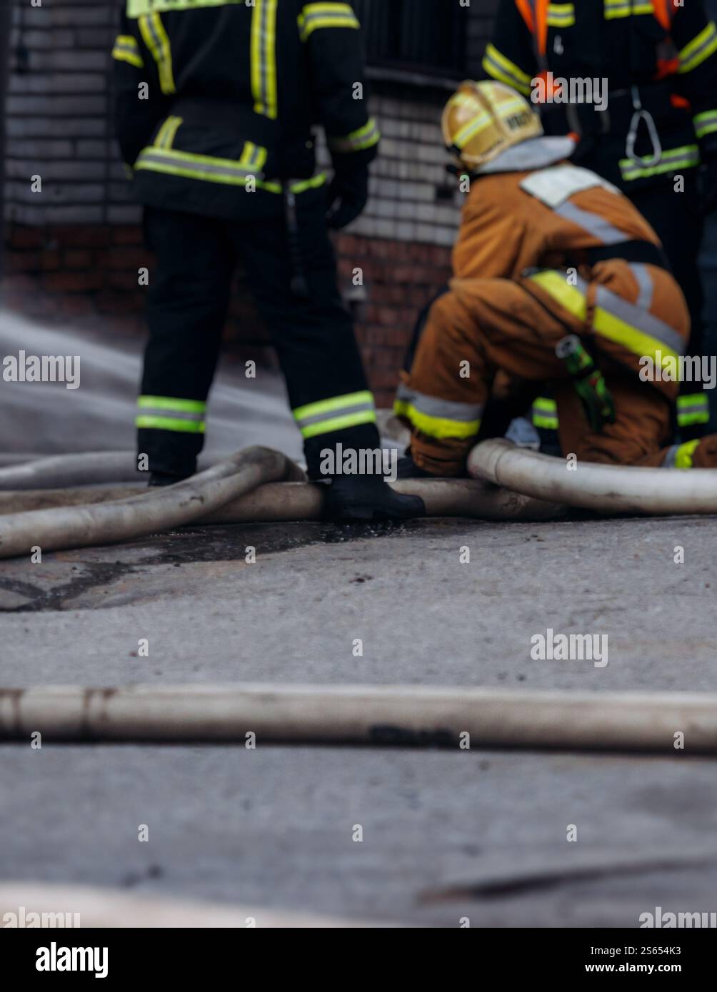 Group of fire men in uniform during fire fighting operation in the city ...