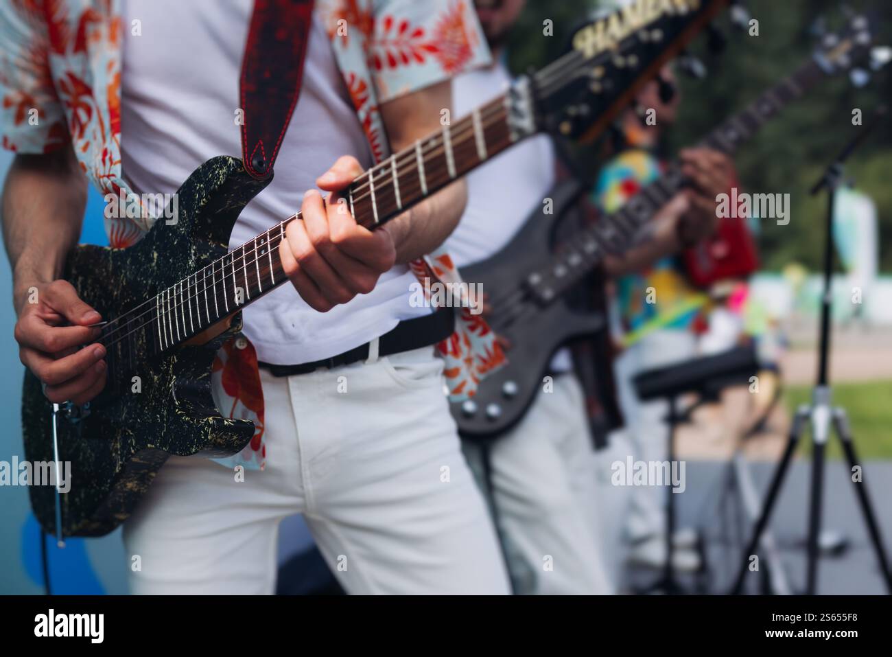 Concert view of electric guitar player with a vocalist and rock band ...