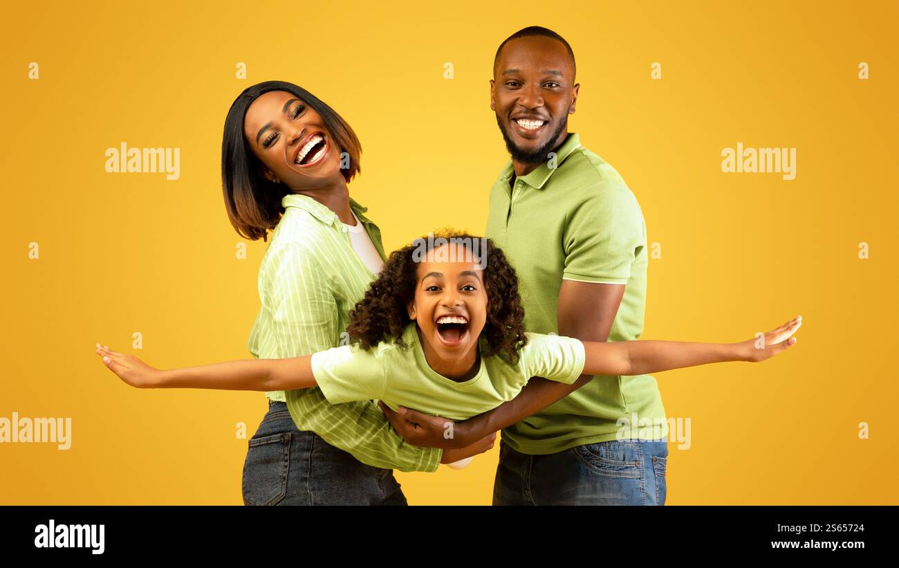 Family bonding concept. Joyful black man and woman holding daughter on ...