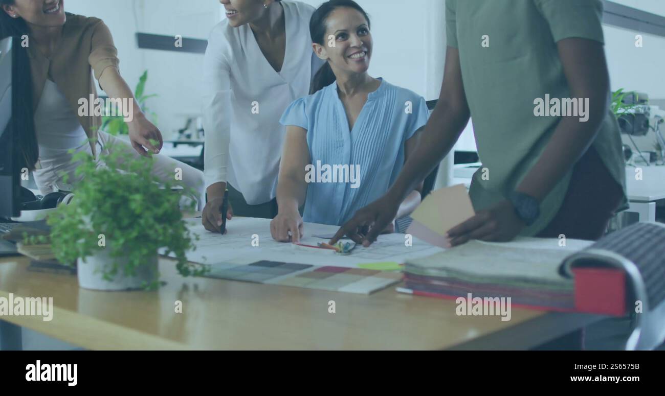 Image of diverse team collaborating on project in office Stock Photo ...