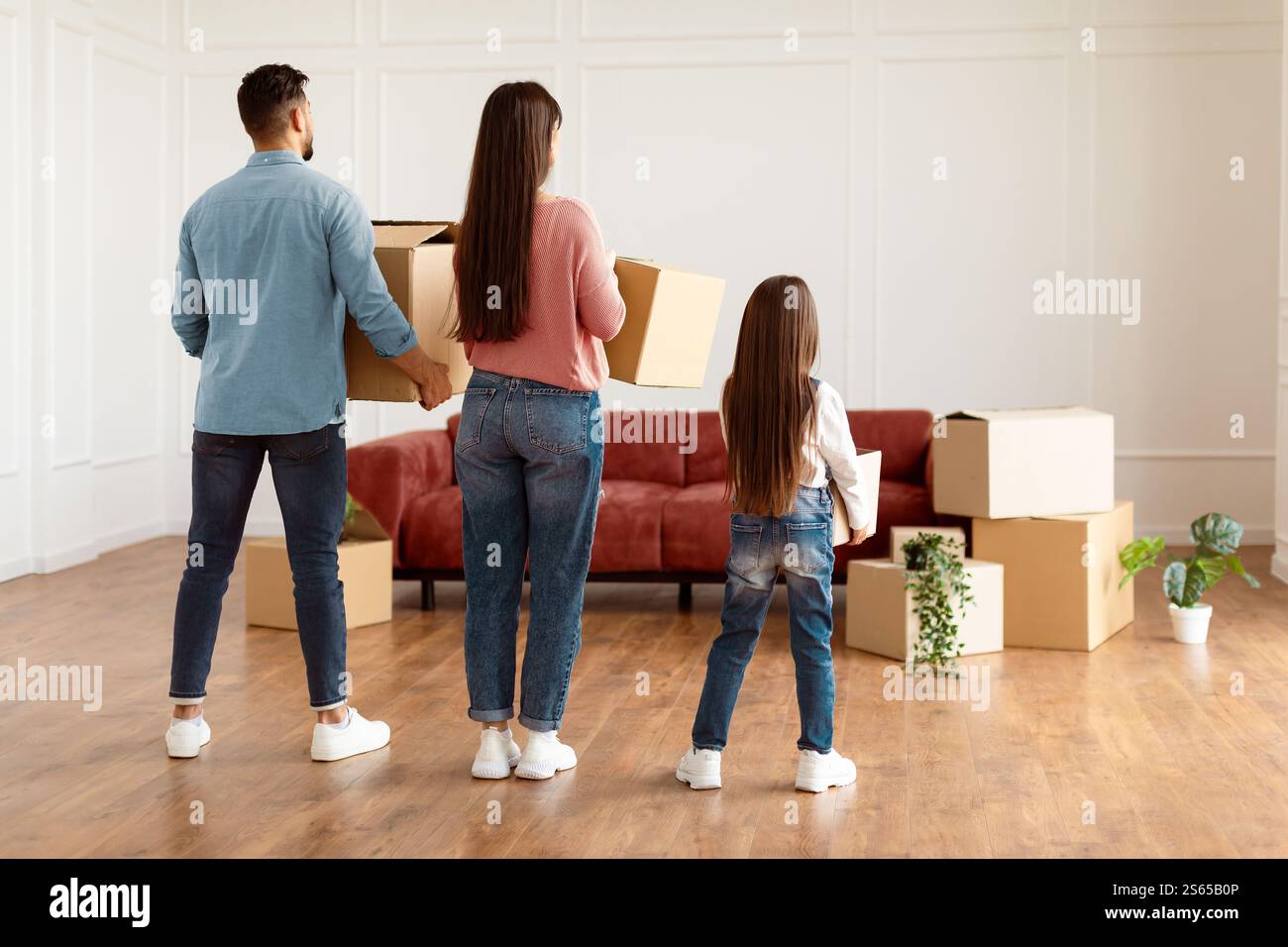 Back view of family carrying boxes in new flat Stock Photo - Alamy