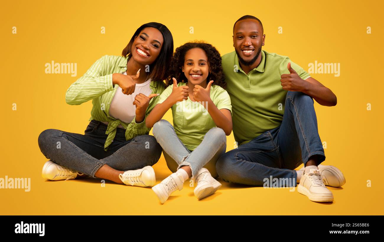 Positive african american family of three showing thumbs up ...