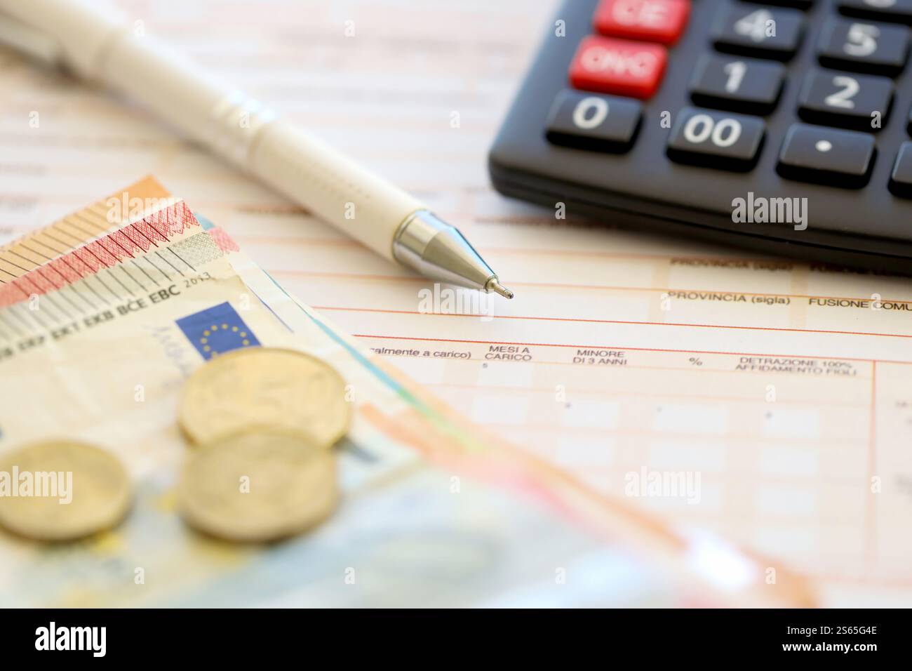 Filling italian tax form process with pen, calculator and euro money ...