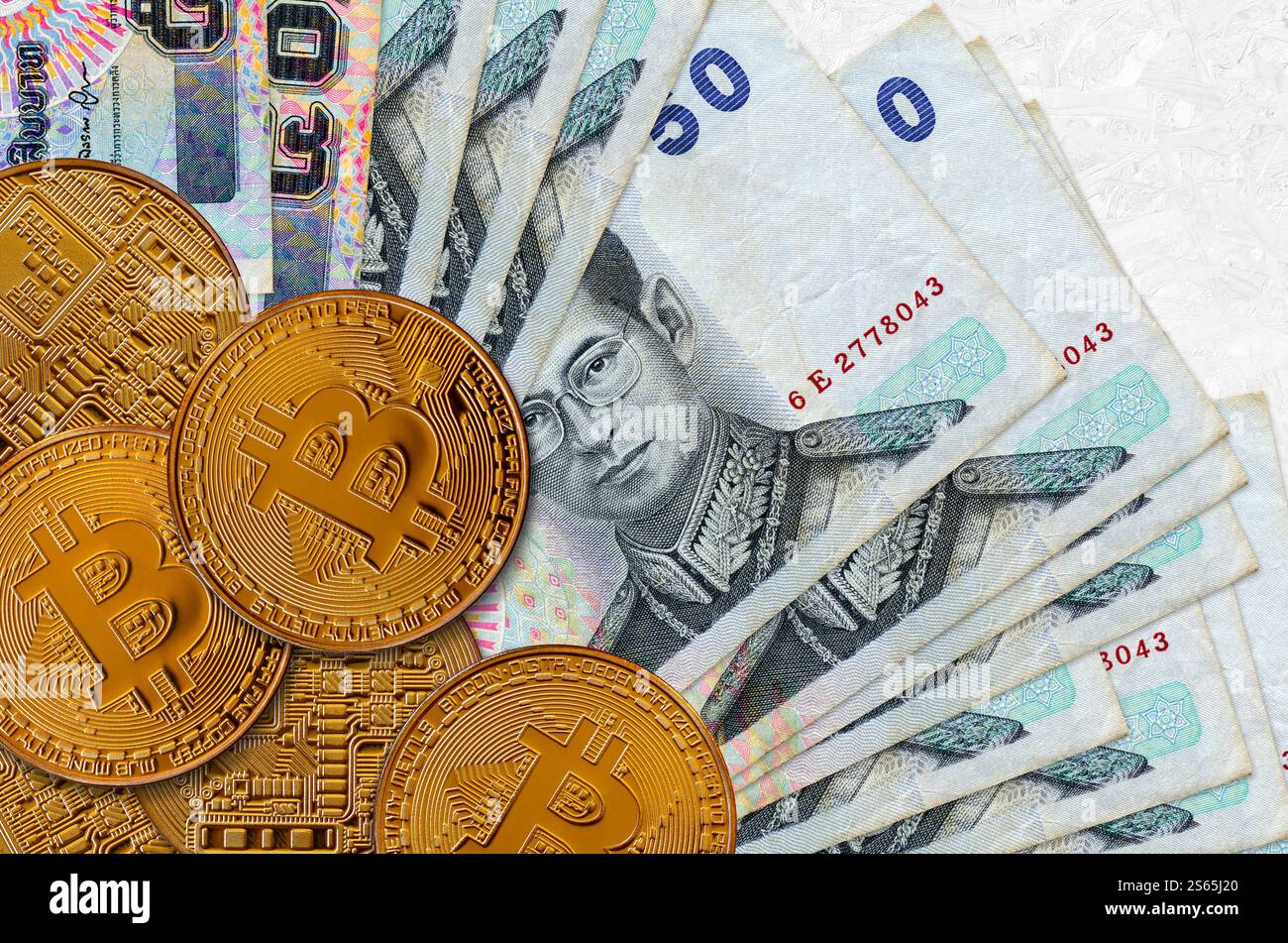 50 Thai Baht bills and golden bitcoins. Cryptocurrency investment ...