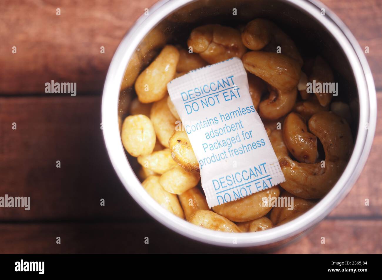 A container filled with cashew nuts accompanied by a desiccant pack ...