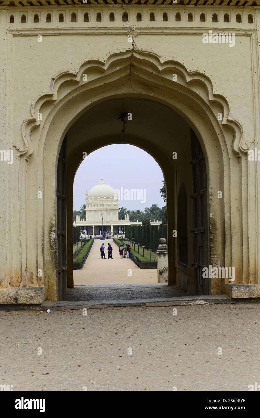 View through an ornate Tor tor of a historic dome and visitors on a ...