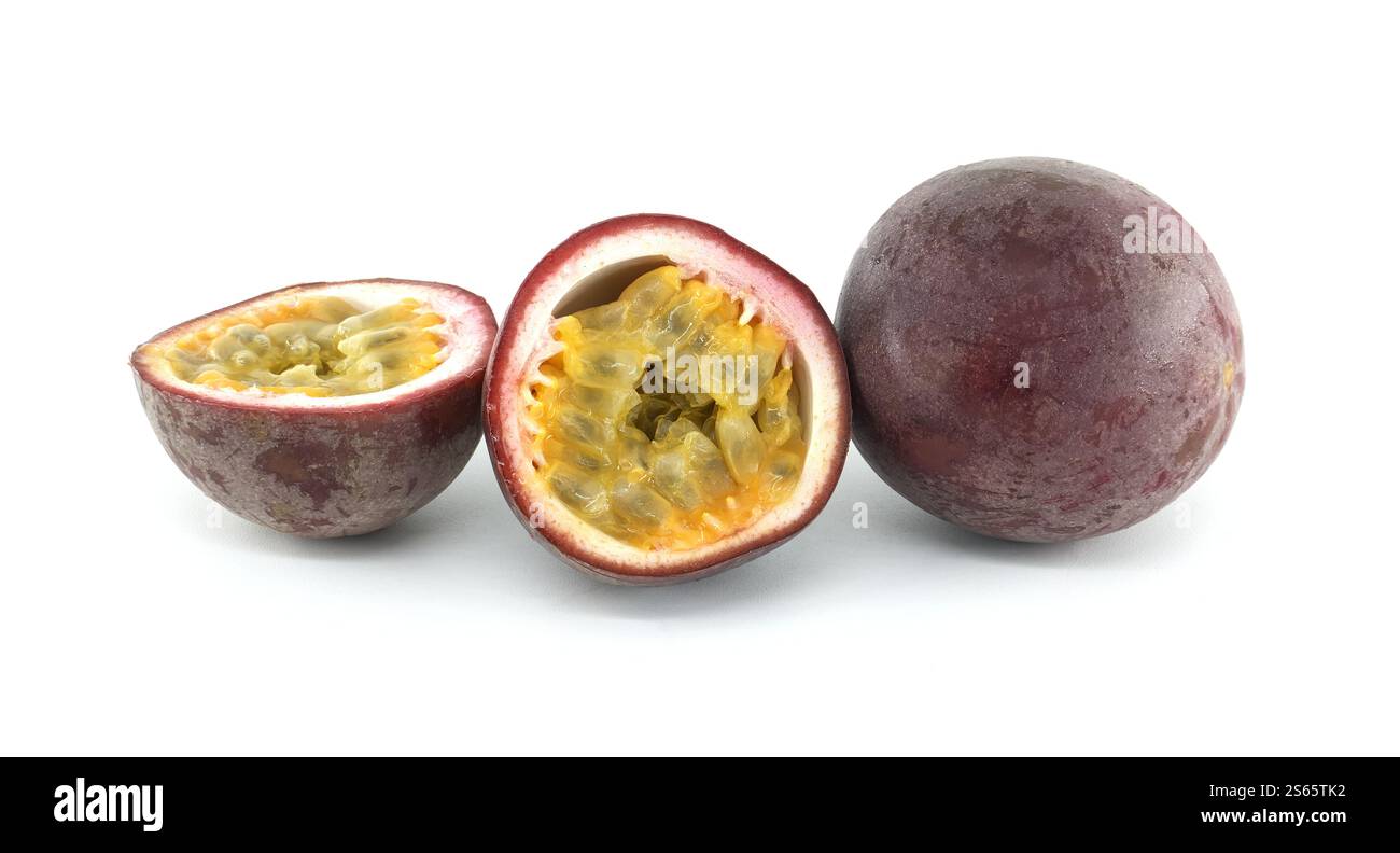 One whole passion fruit and two halves exposing the pulp with the seeds ...